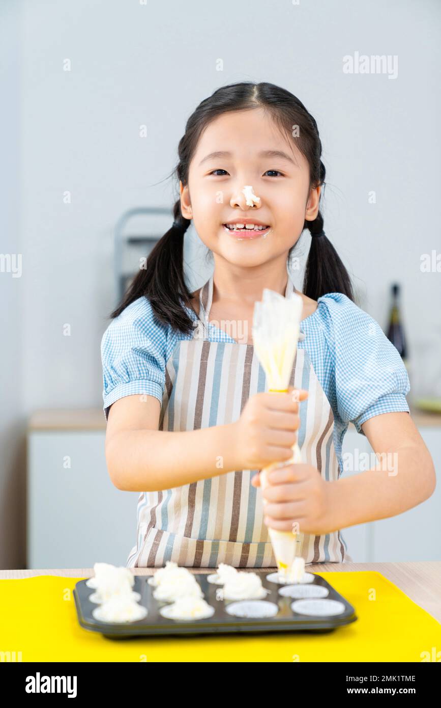 Happy little girl making cakes Stock Photo - Alamy