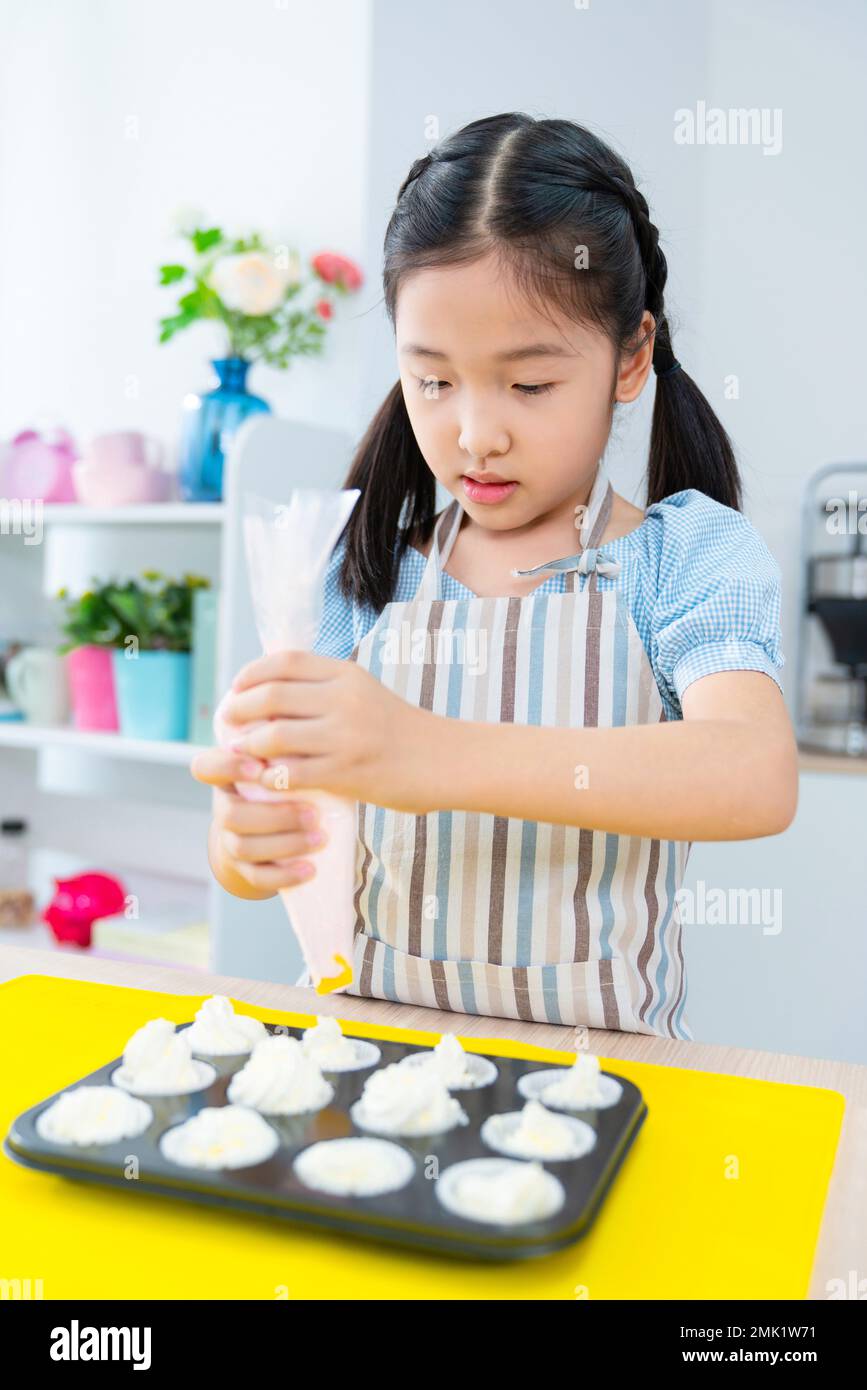 Happy little girl making cakes Stock Photo - Alamy