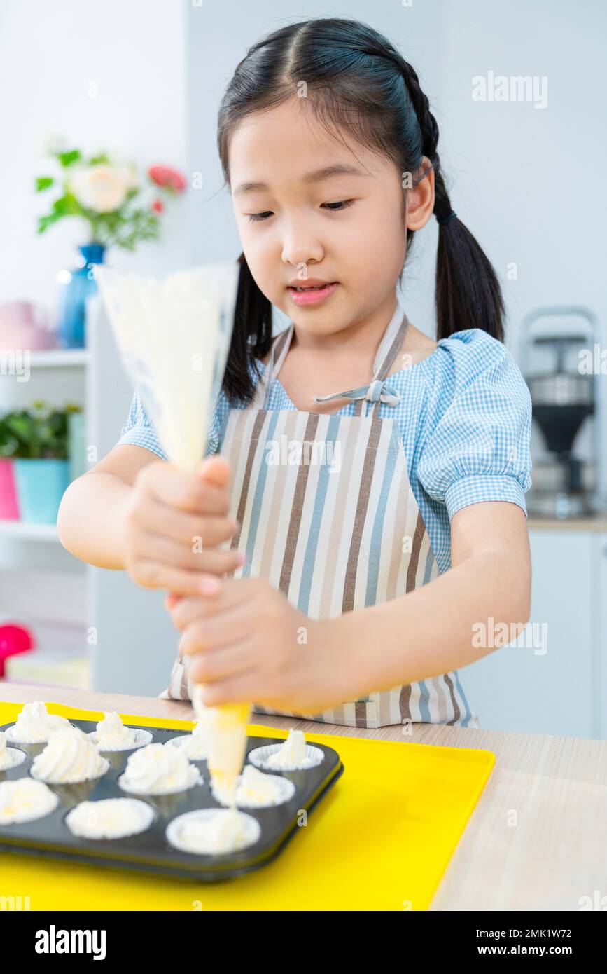 Happy little girl making cakes Stock Photo - Alamy