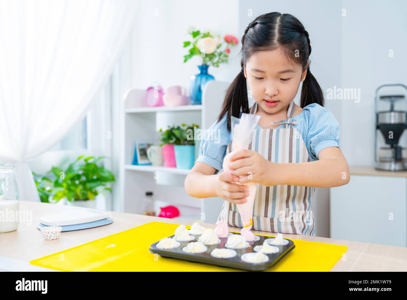 Happy little girl making cakes Stock Photo - Alamy