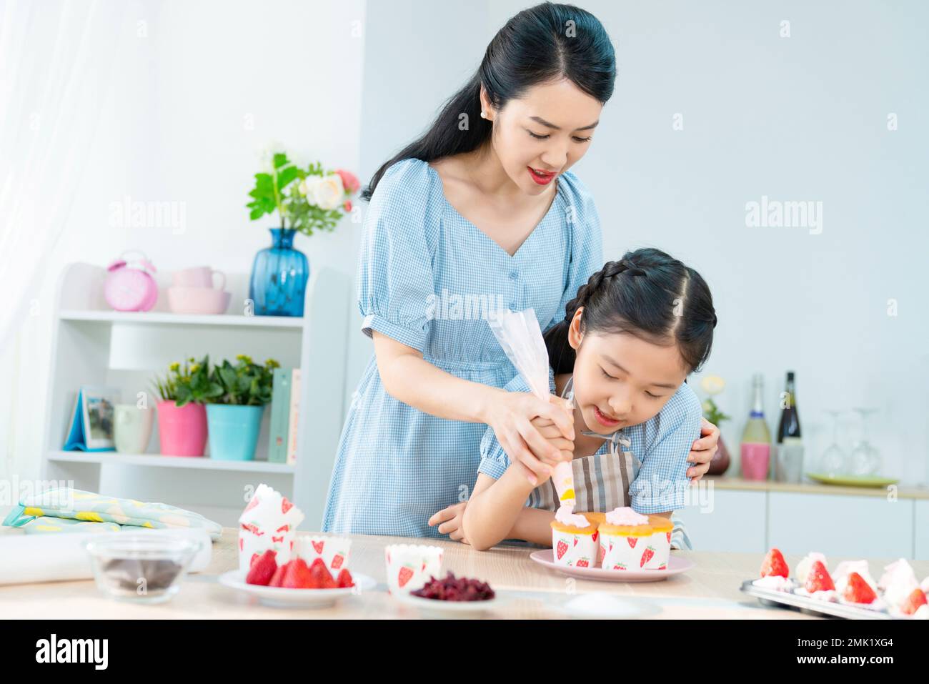 Happy young mother and daughter together making cakes Stock Photo - Alamy