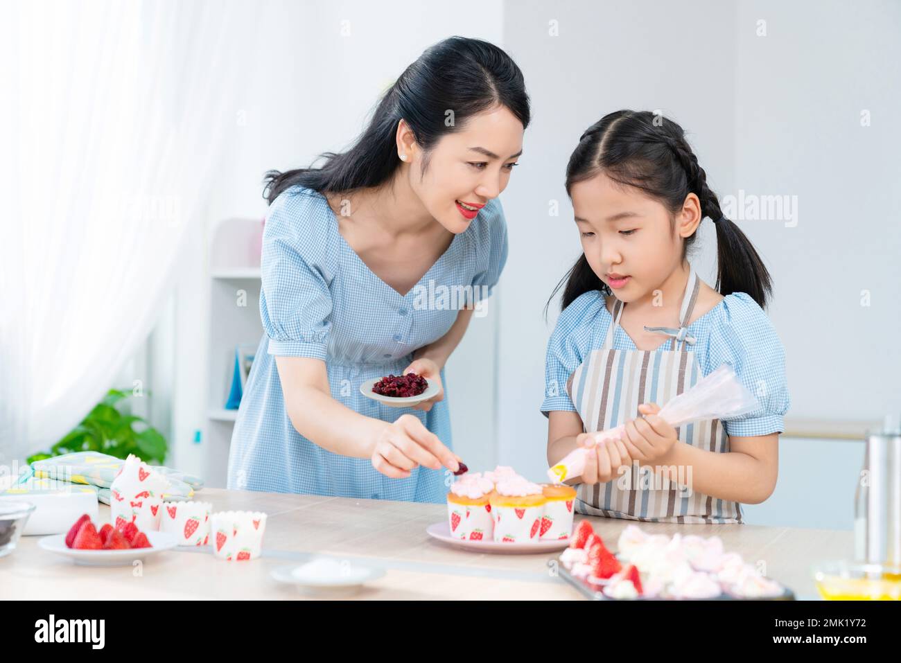 Happy young mother and daughter together making cakes Stock Photo - Alamy