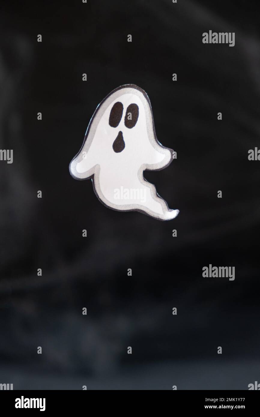 A frightening white ghost flies on a black background with a web, a ...