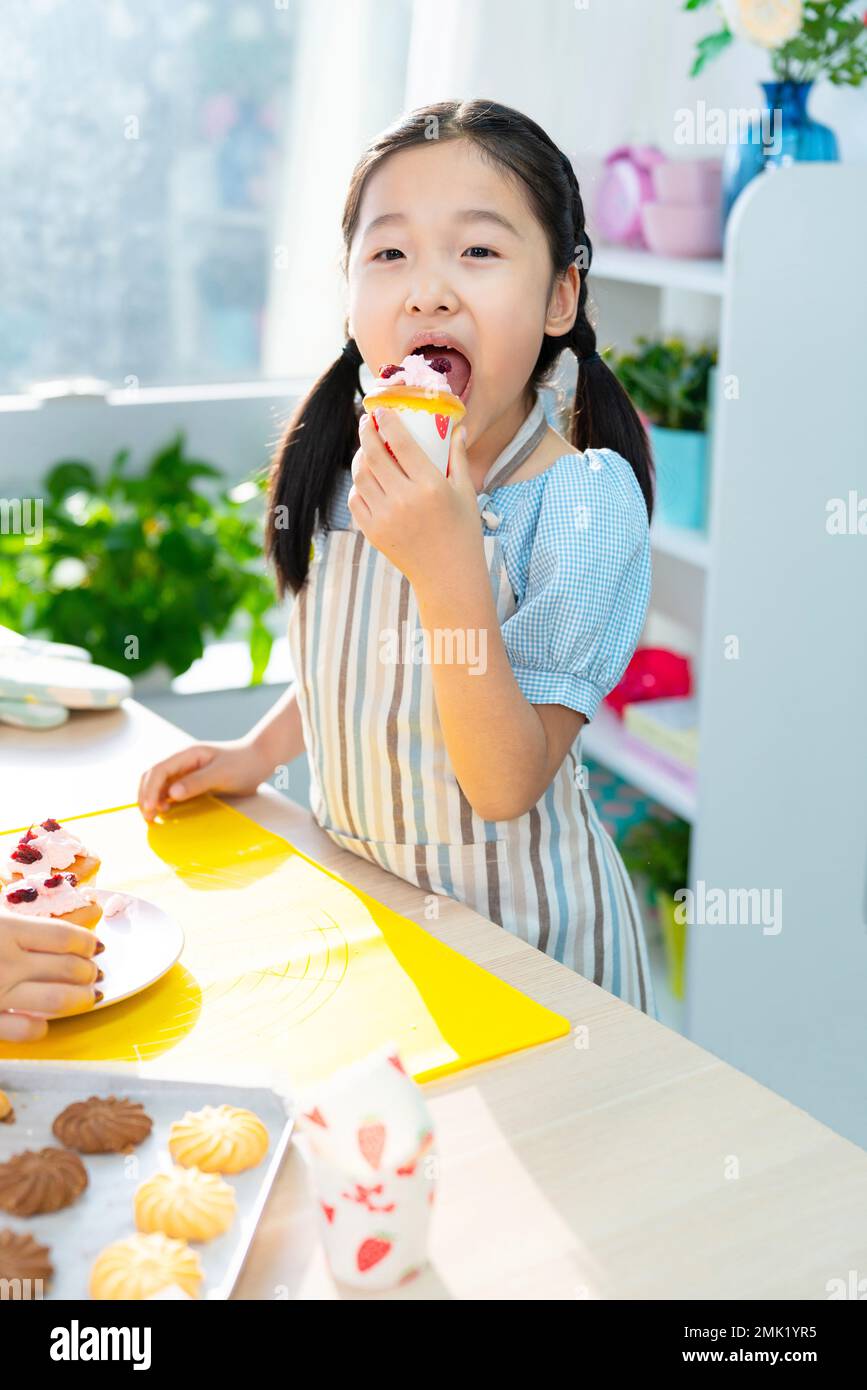 Happy little girl making cakes Stock Photo - Alamy