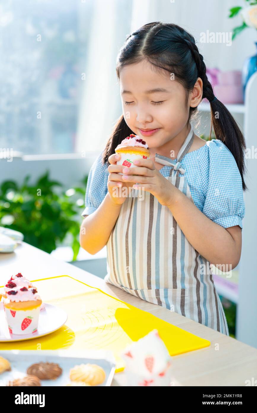 Happy little girl making cakes Stock Photo - Alamy