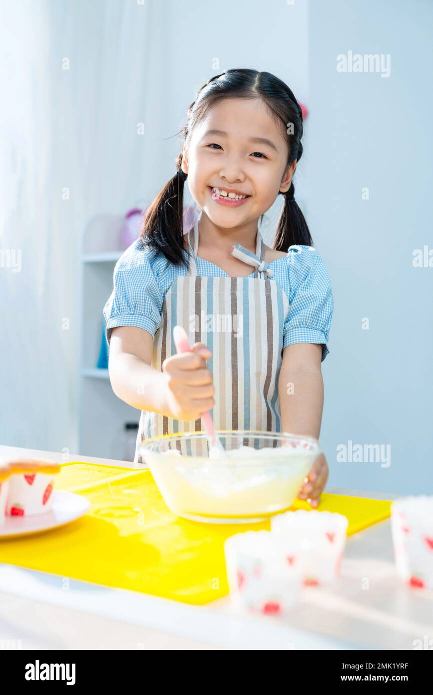 Happy little girl making cakes Stock Photo - Alamy