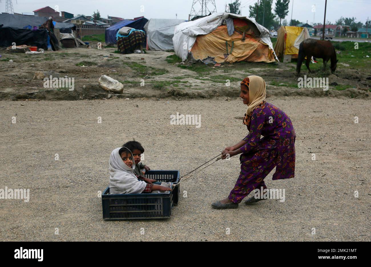 A Bakarwal nomad girl plays with her siblings at their temporary camp ...