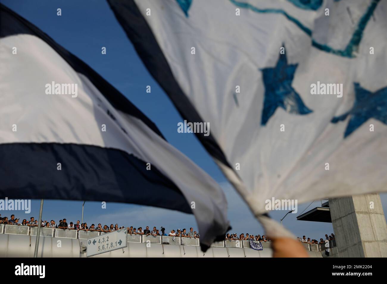 Monterrey fans wave flags as they wait to greet the team bus outside ...