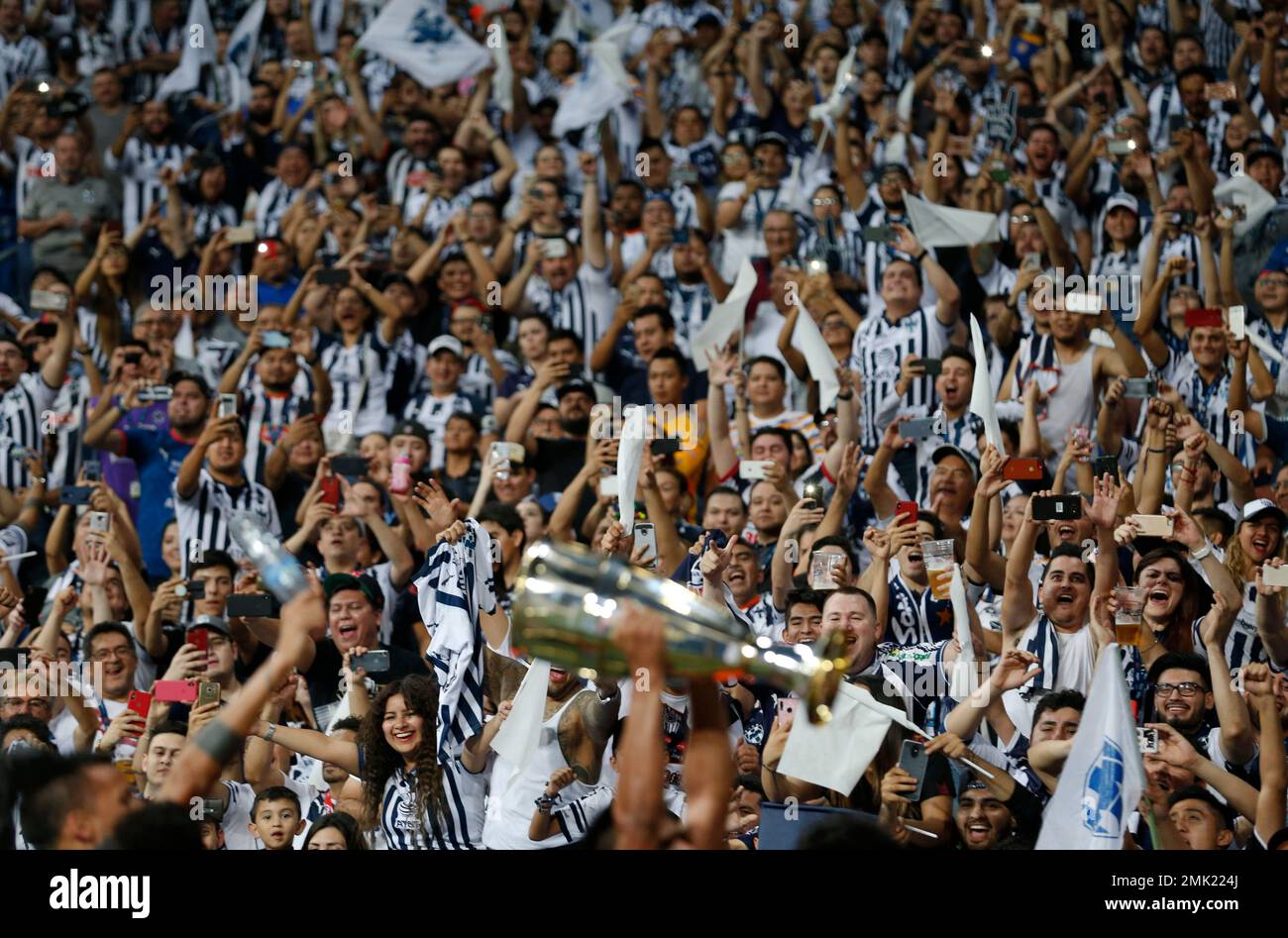 Monterrey fans cheer as a player holds the trophy aloft after Monterrey ...