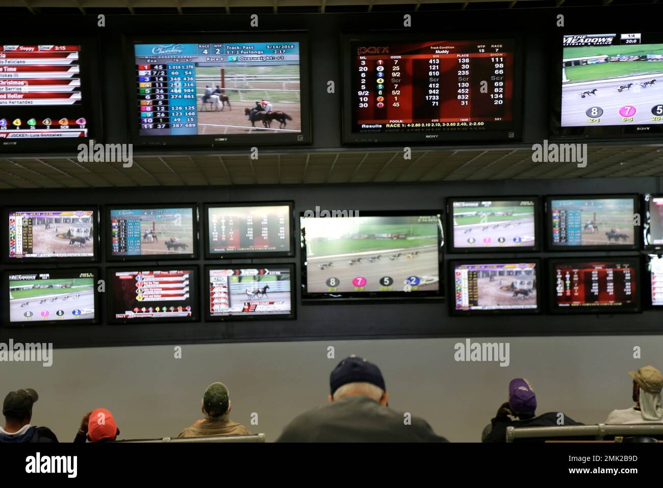 FILE - In this May 14, 2018, file photo, men watch horse racing on an ...