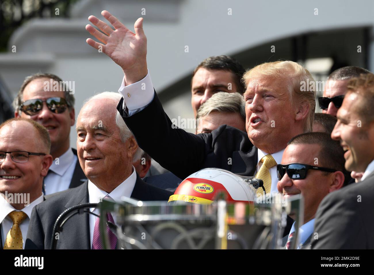 President Donald Trump waves as he poses for pictures during an event ...