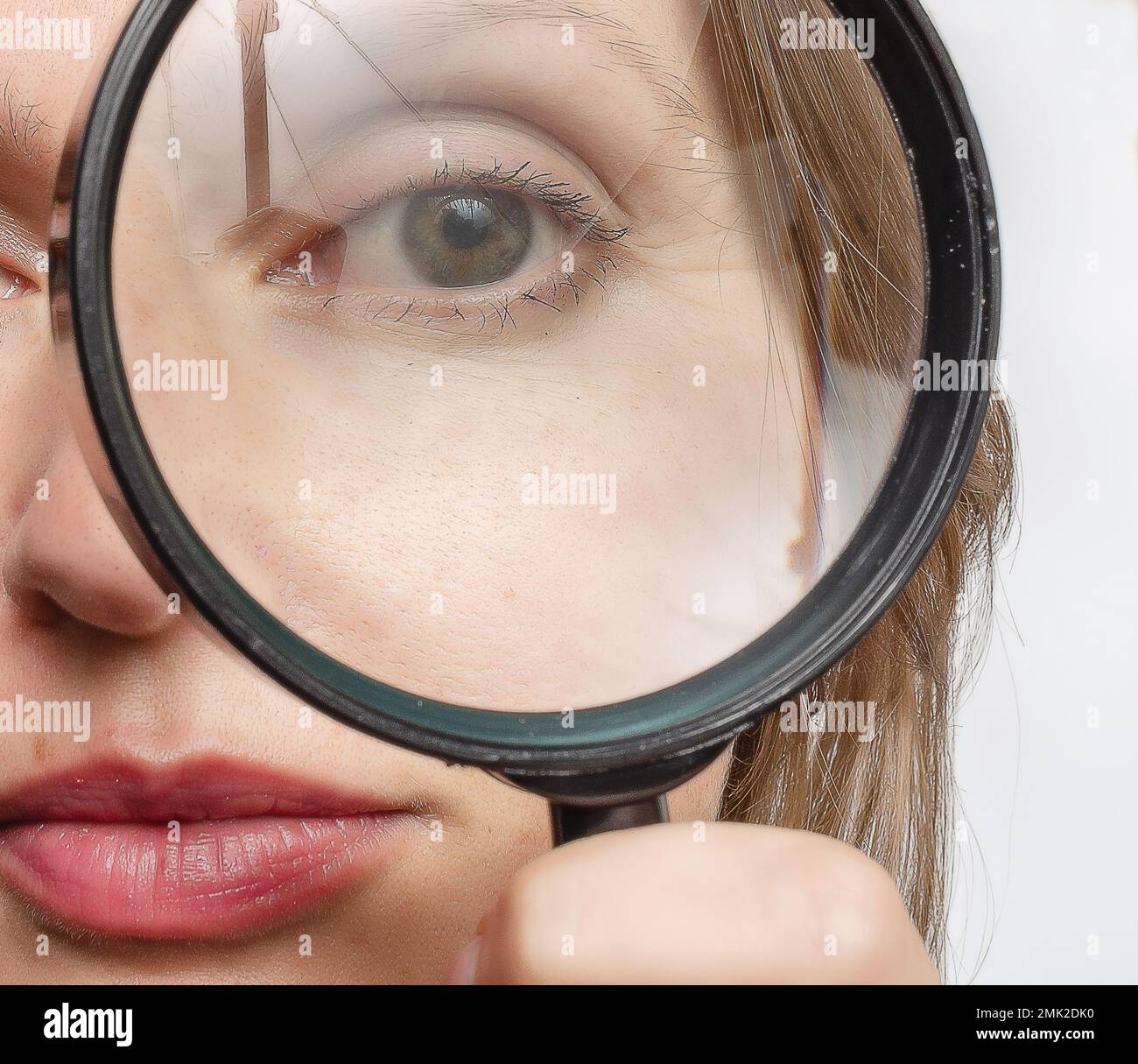 Adult woman's eye seen through magnifying glass Stock Photo - Alamy