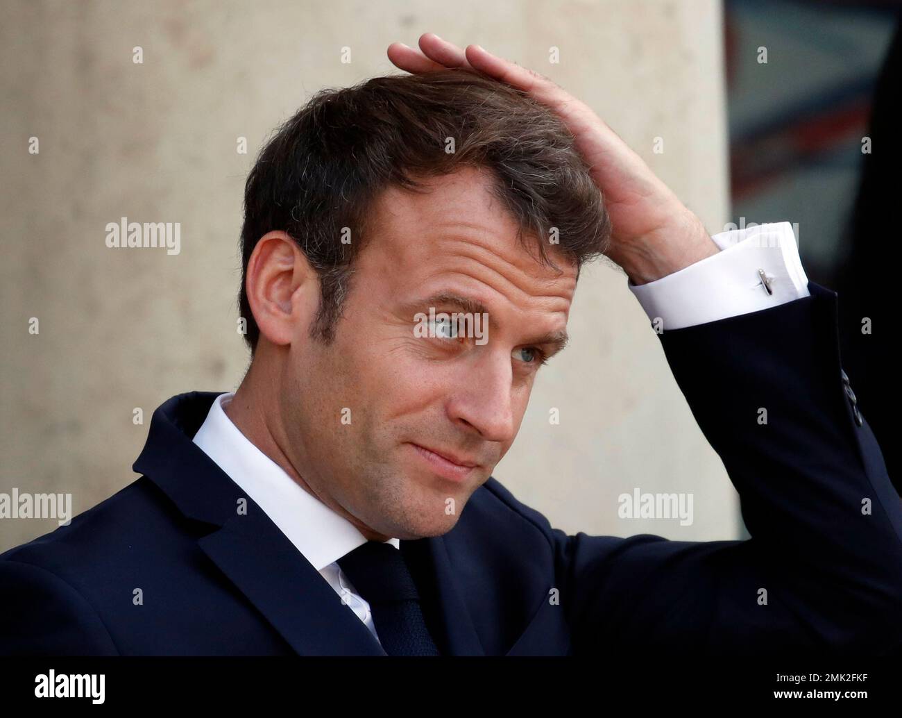 French President Emmanuel Macron adjusts his hair after a meeting with ...