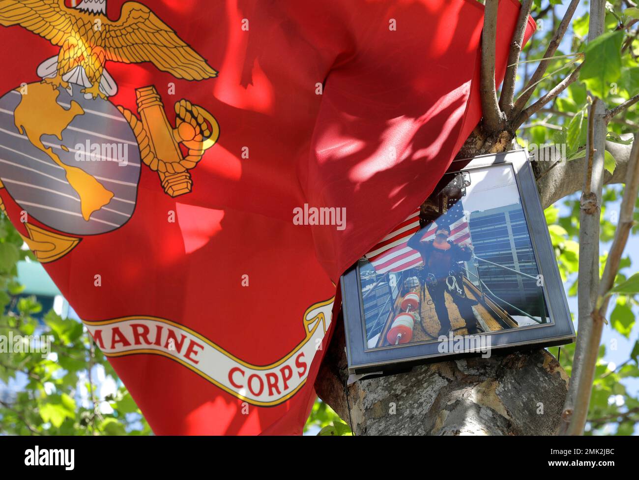 A photo of Andrew Yoder hangs on a tree next to a Marine Corps. flag ...
