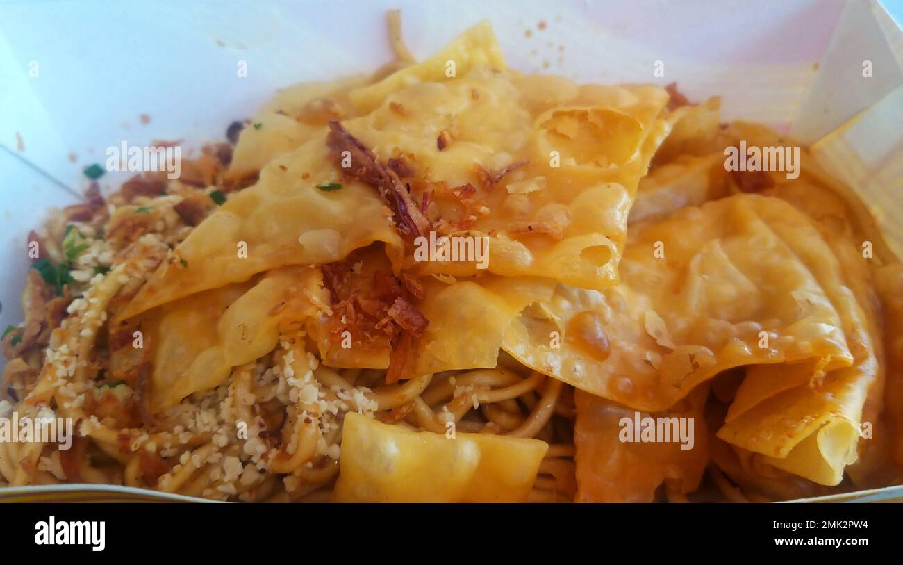 food in the form of noodles with a mixture of various toppings and ...