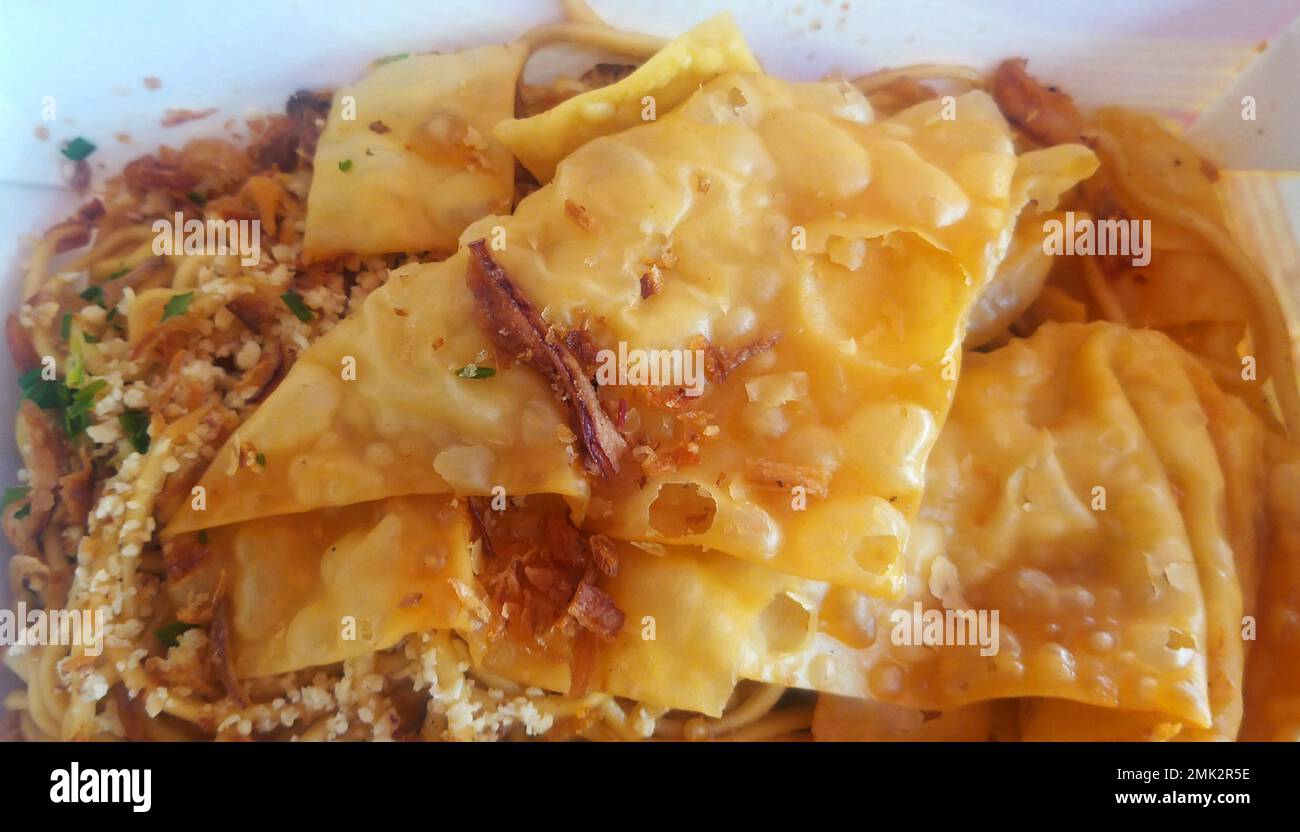 food in the form of noodles with a mixture of various toppings and ...