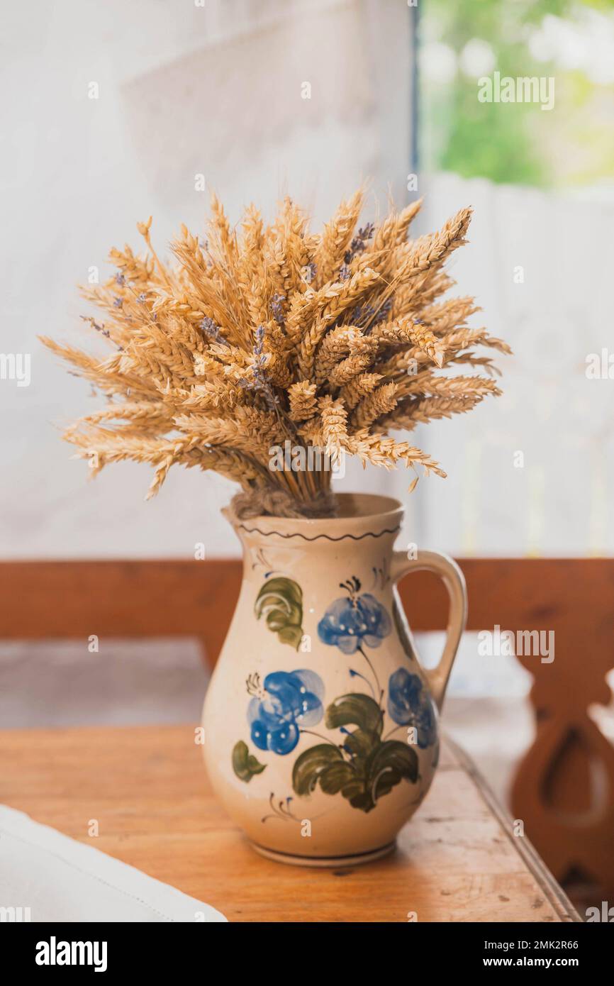 Ceramic jug with a bouquet of wheat in an old hut Stock Photo - Alamy