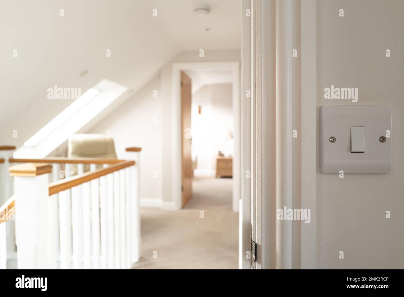 Shallow focus of a light switch seen at the exit to a bedroom. A large ...