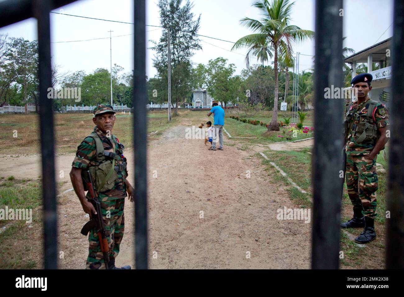 Soldiers stand guard at a church garden with a locked gate in Ampara ...