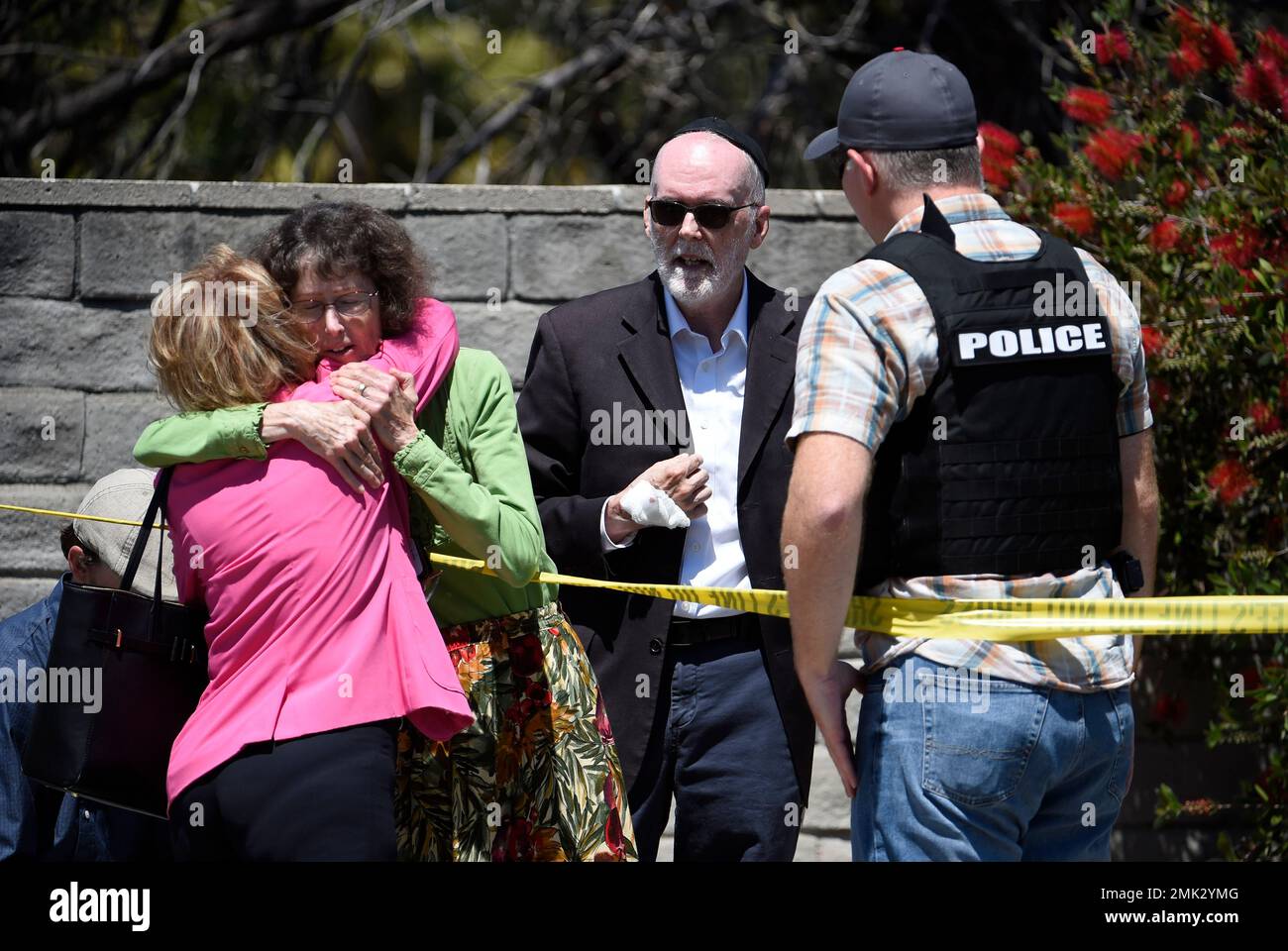 Two people hug as another talks to a San Diego County Sheriff's deputy ...