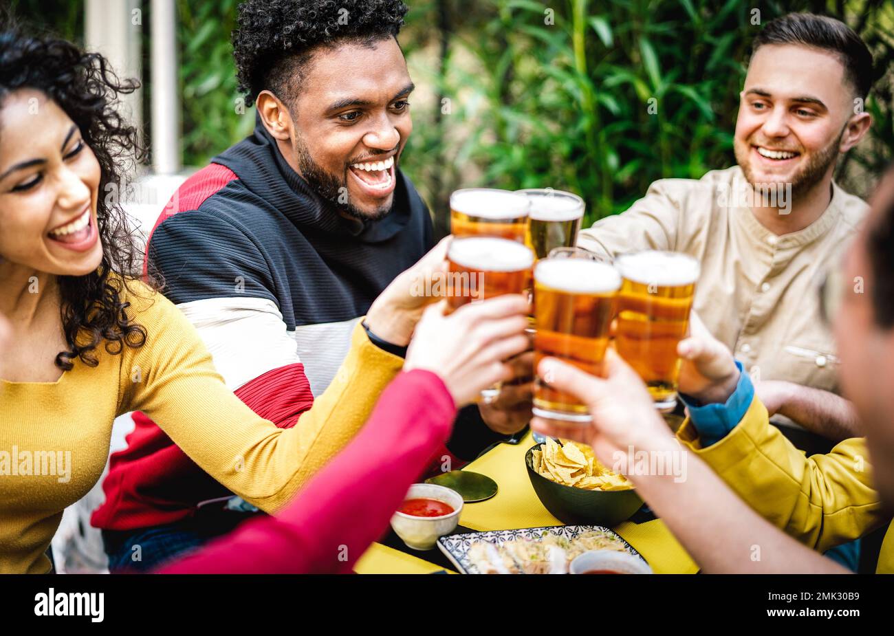 Multicultural friends drinking beer at brewery pub garden - Genuine ...