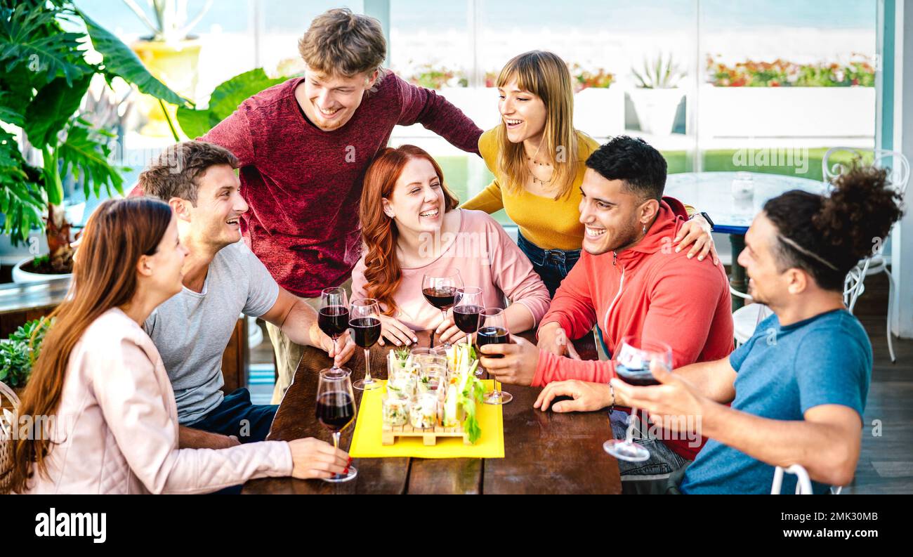 Young friends having fun together tasting wine at rooftop by private ...