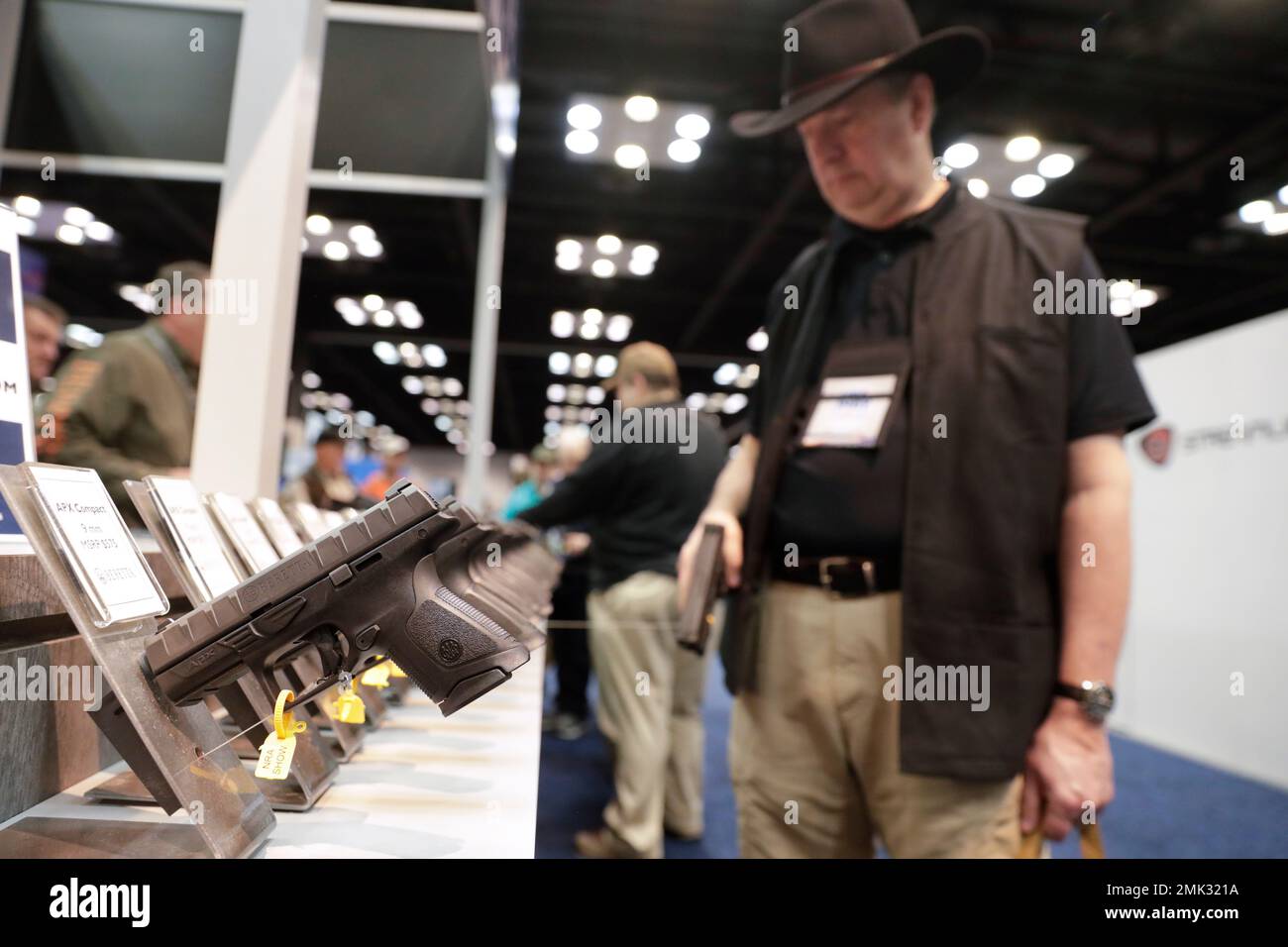 A gun enthusiast looks over the display of Beretta pistols on display ...