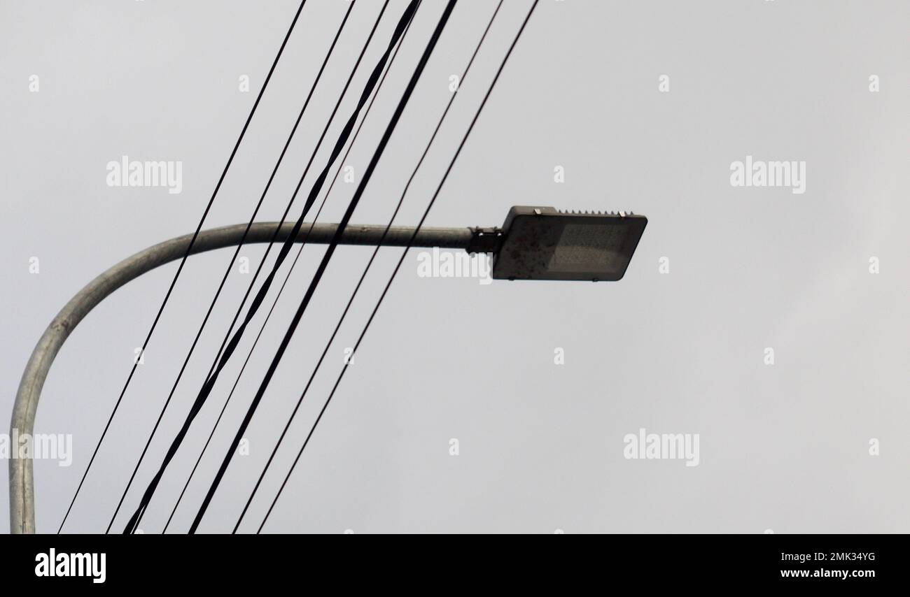 black electrical wires forming parallel lines and a street lamp Stock ...