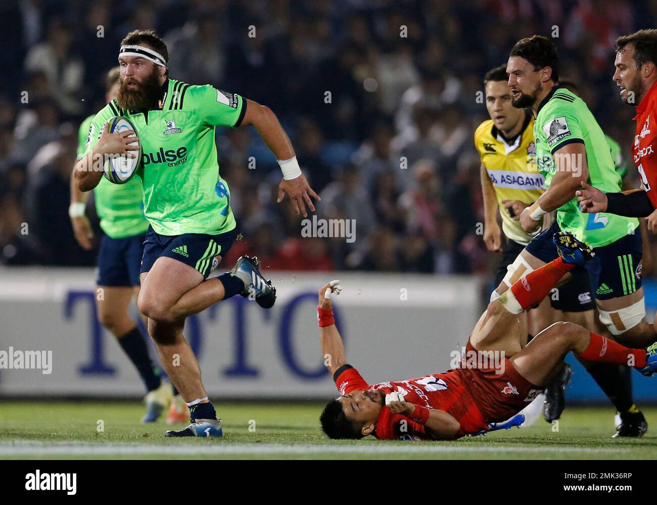Highlanders Liam Coltman, left, runs past Sunwolves Fumiaki Tanaka ...