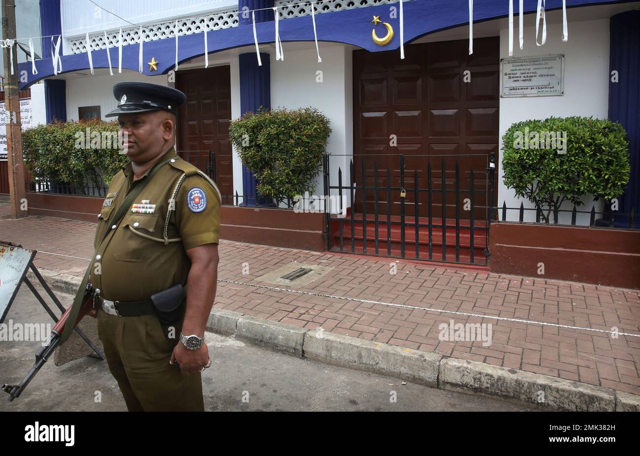 A Sri Lankan policeman stands guard outside a mosque closed for Friday ...