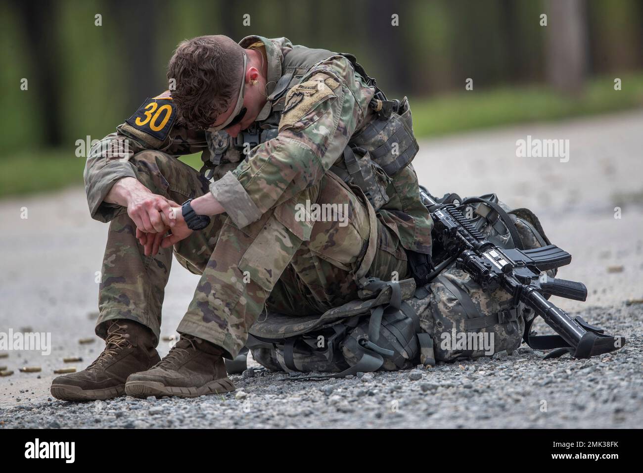 A competitor takes a brief rest as a firing range is readied for the ...