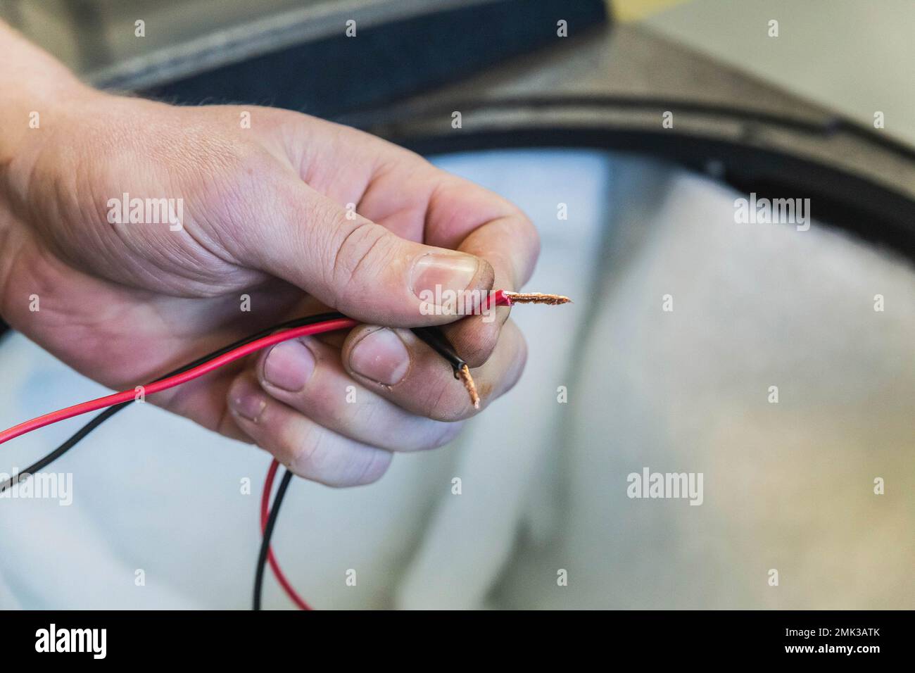 Worker holds two wires in his hand close-up Stock Photo - Alamy