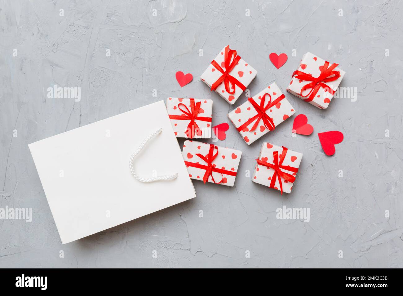 Gift boxes pop out from paper bag top view on colored background. bag ...