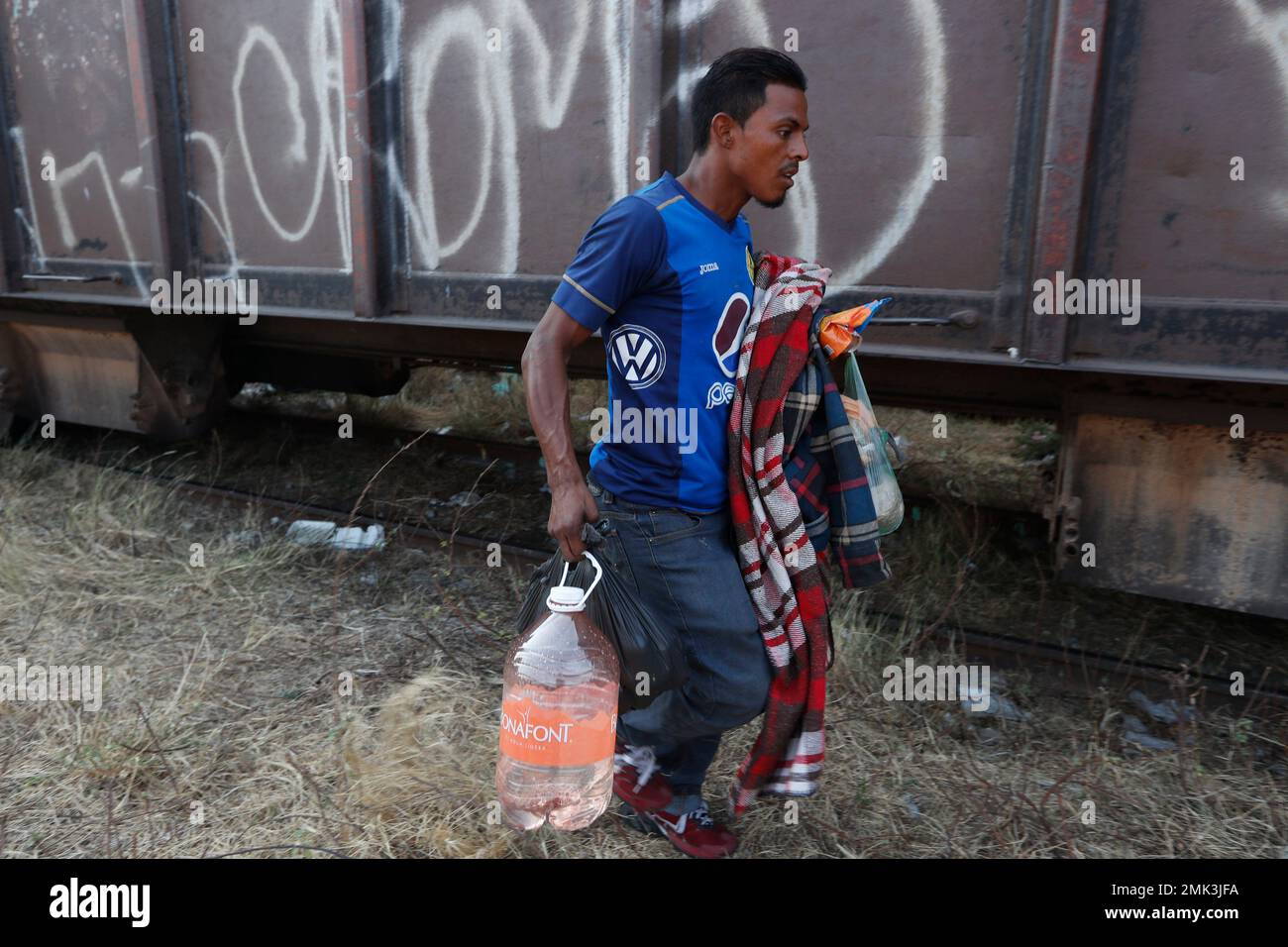 A Central American migrant runs to climb on a passing freight train on ...
