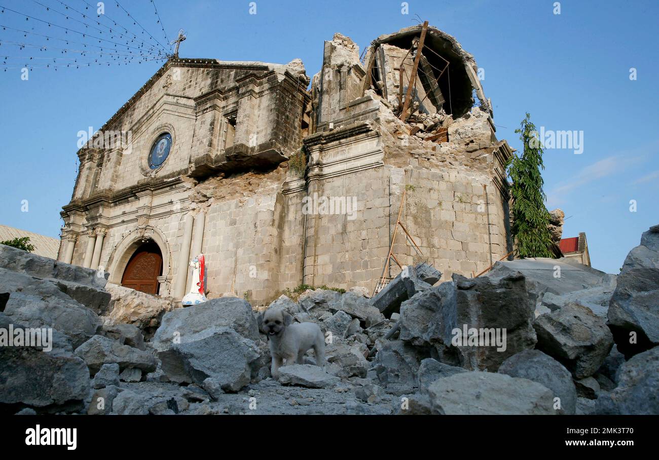 The damage of St. Catherine church, with its headless statue, is seen ...