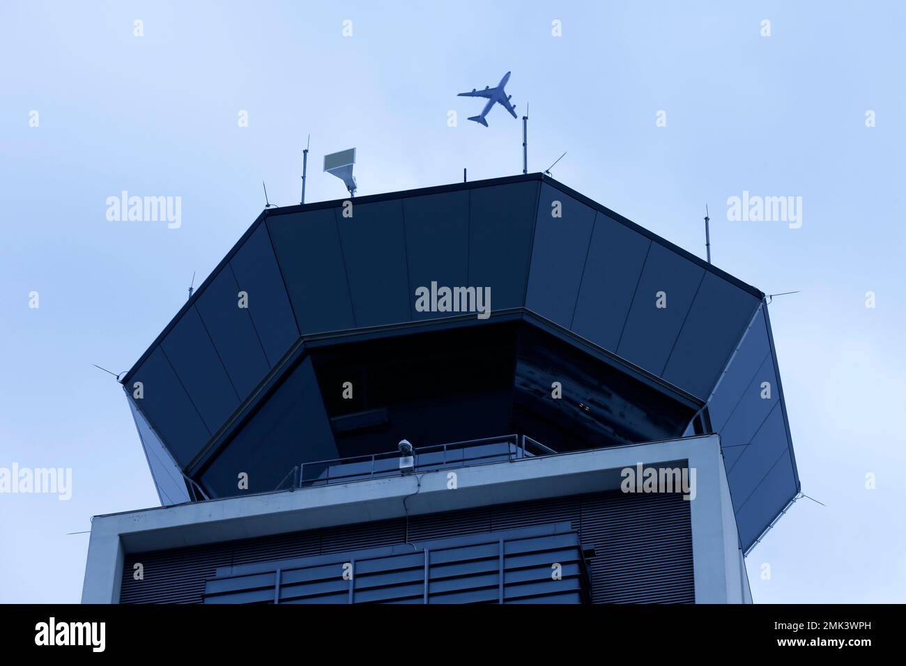 A plane flies over the south air traffic control tower at O'Hare ...