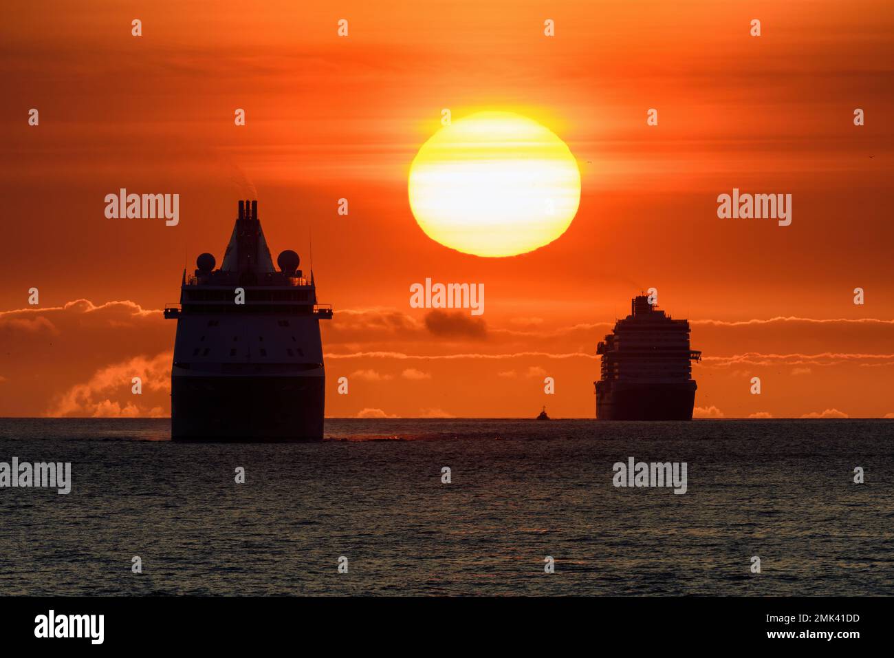 A sunrise view of silhouetted cruise ships sailing into port Stock ...