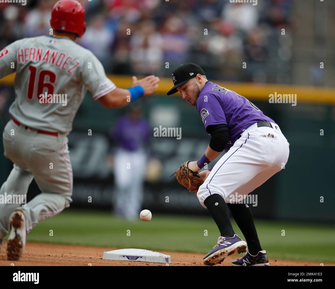 Colorado Rockies second baseman Garrett Hampson, back, drops the throw ...