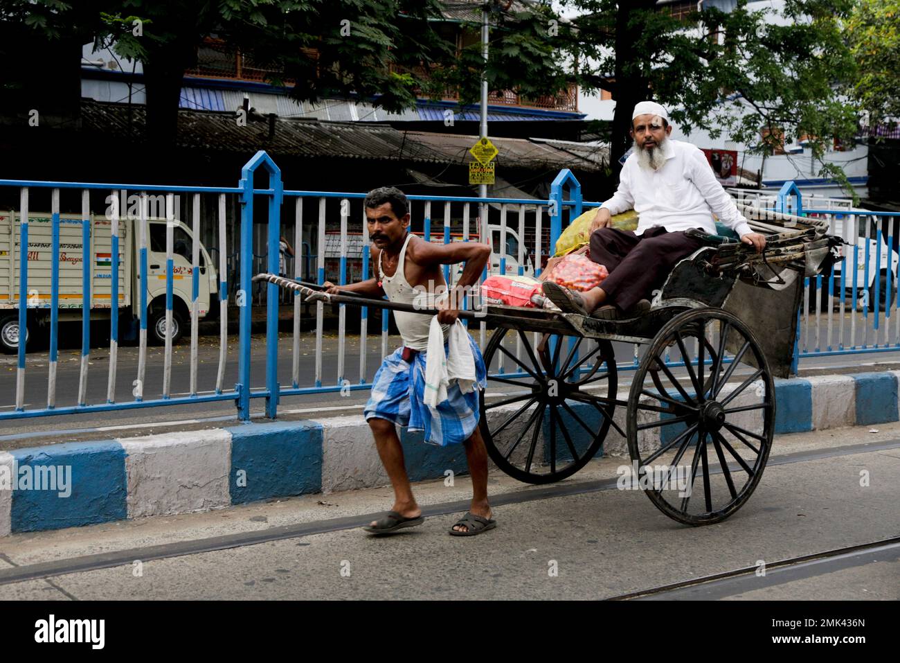 An Indian Muslim trader ride on a hand-pulled rickshaw with sacks of ...