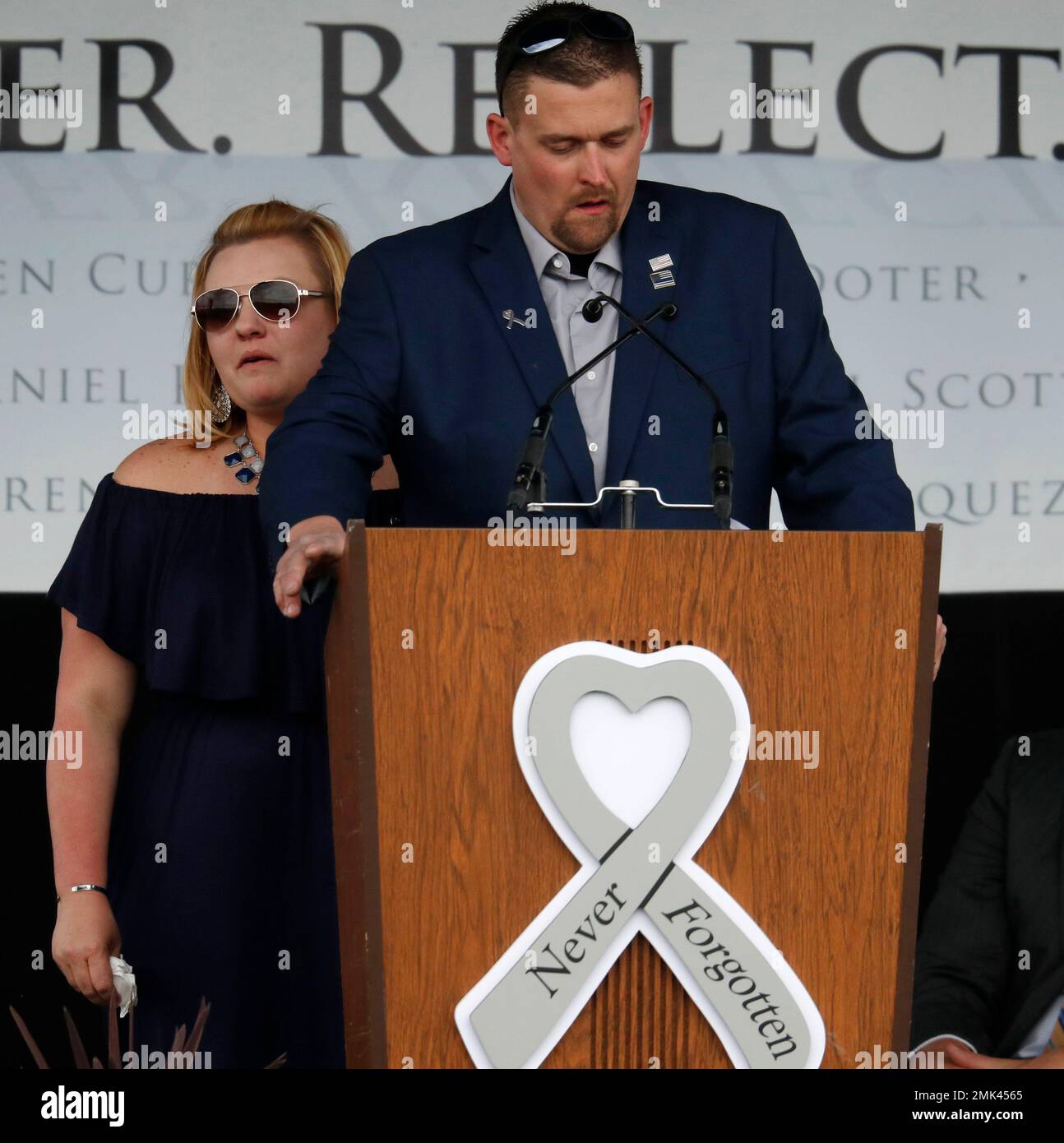 As his wife, Kara, left, looks on, Sean Graves, who was shot during the ...