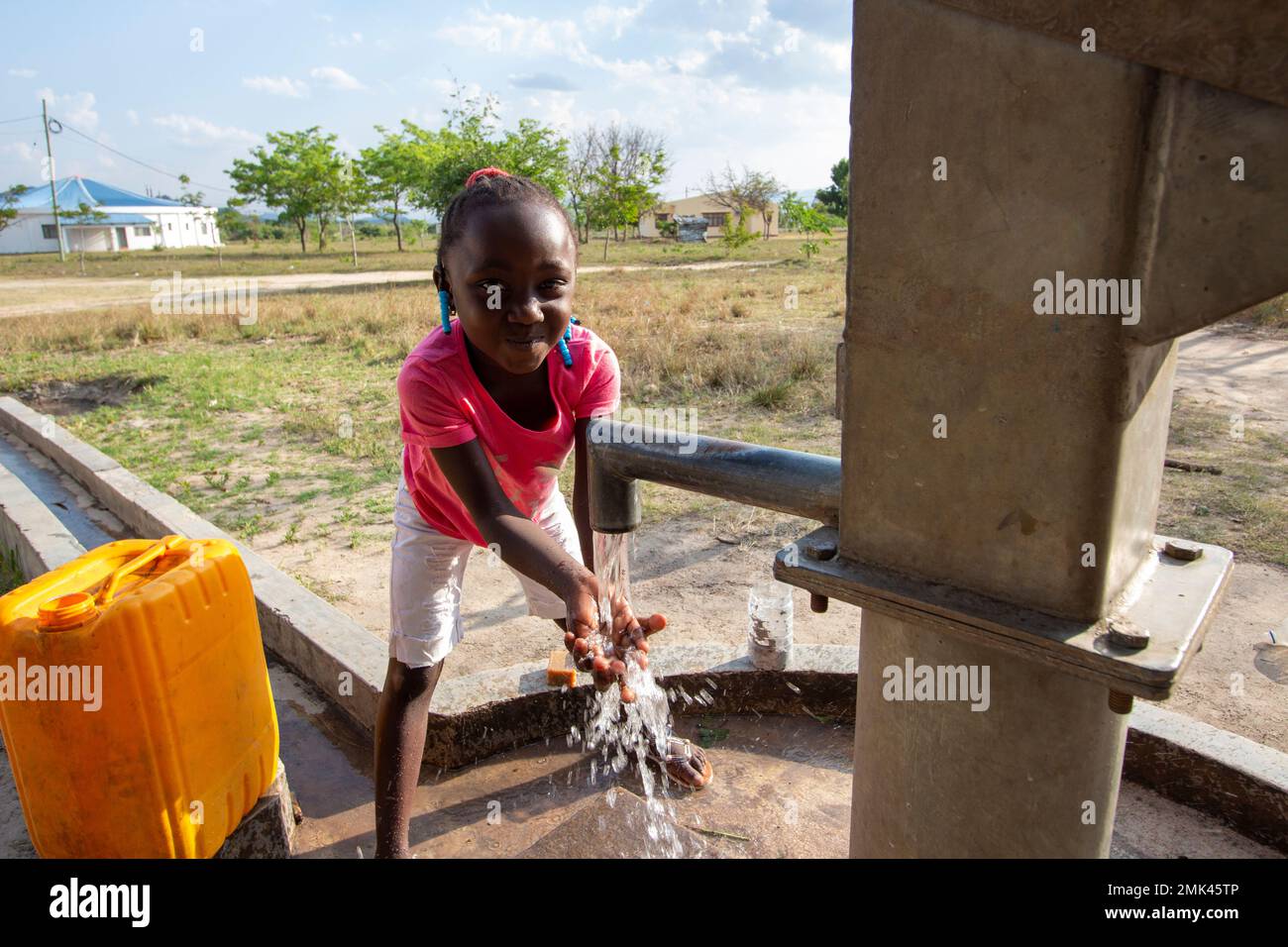 Promoting Good Hygiene: Young African Girl Washing Hands at a Manual ...