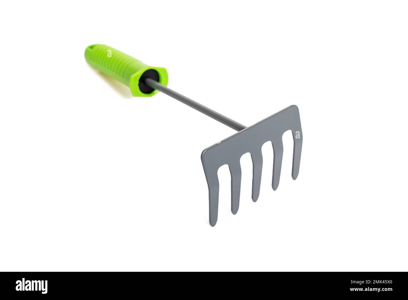 Small garden rake with green plastic handle isolated on a white ...