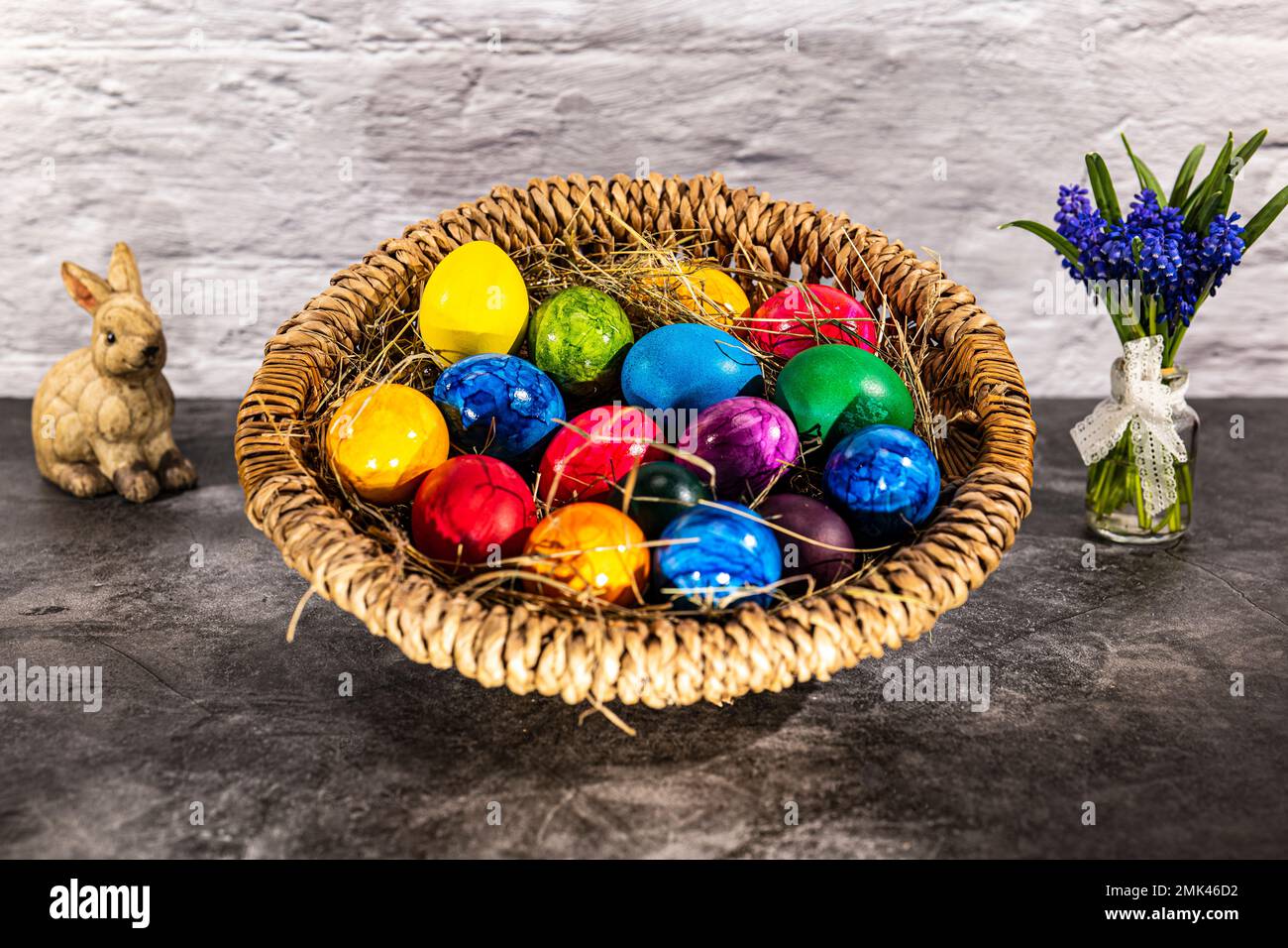Easter nest with hay and many colorful easter eggs, easter bunny and a ...
