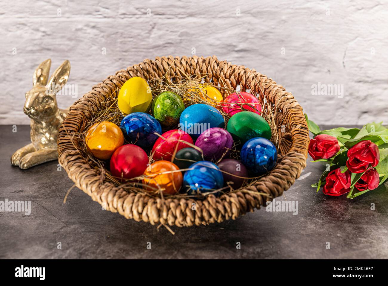 Easter nest with hay and many colorful easter eggs, easter bunny and a ...