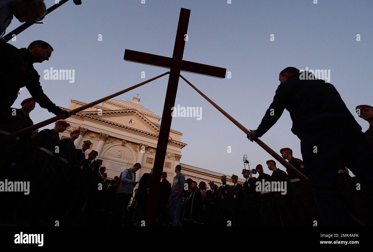 Worshippers hold a cross during a Way of the Cross procession in ...