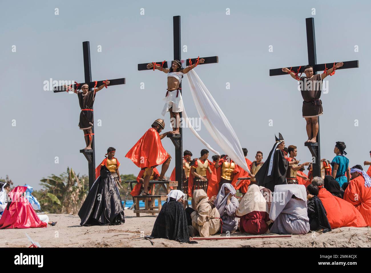 Ruben Enaje, center, dressed as Jesus, is seen nailed on cross for the ...