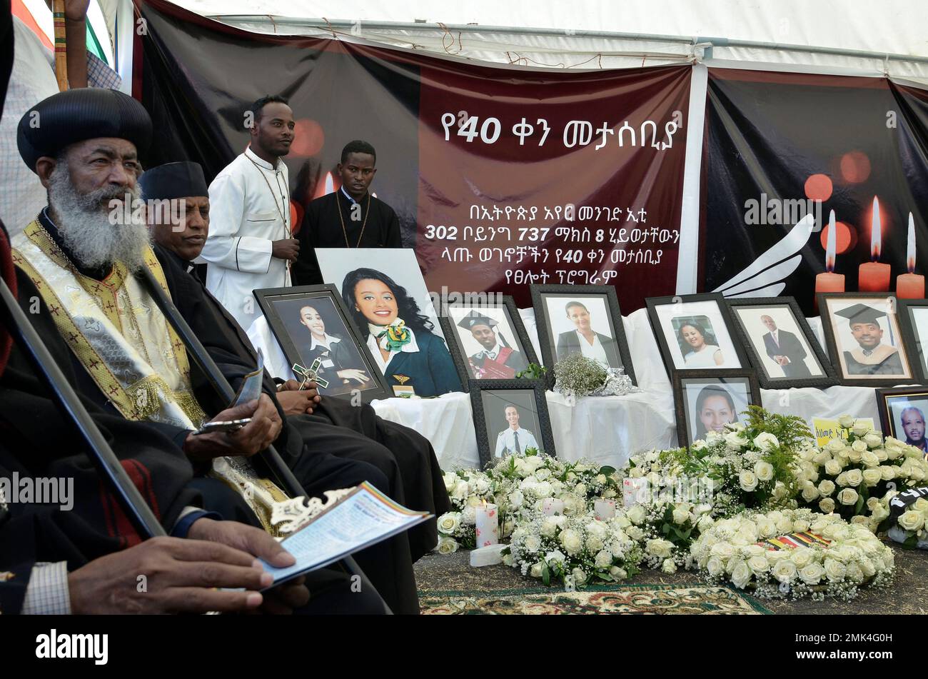 An Ethiopian priest pray as photos of the plane crash victims are ...