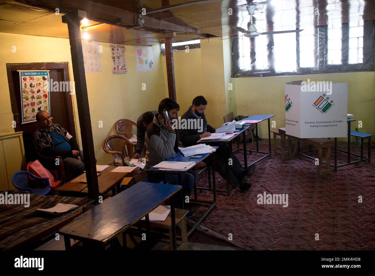 Election officers sit inside an empty polling station during the second ...