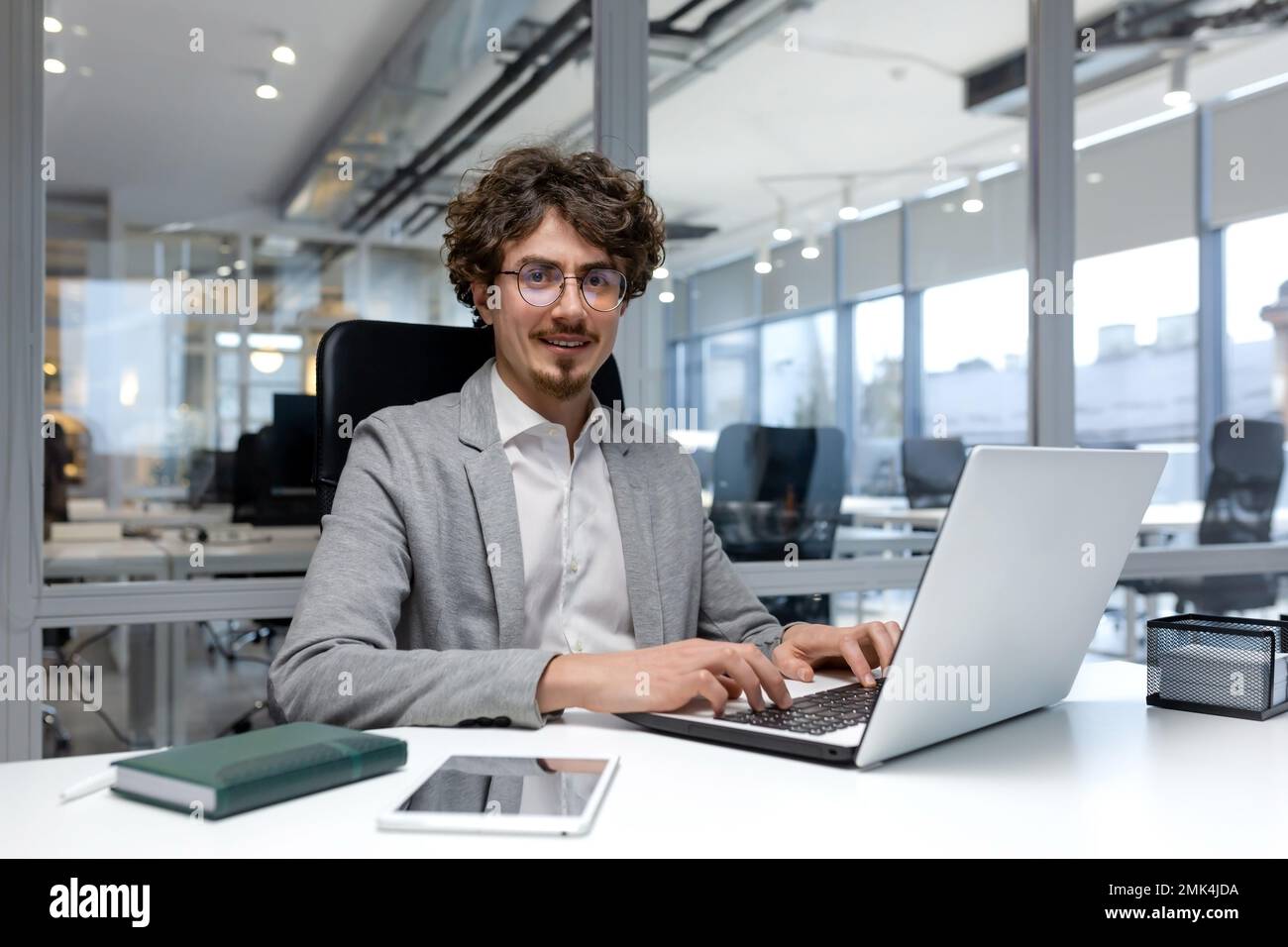 Portrait of hispanic businessman, man with curly hair and beard wearing ...