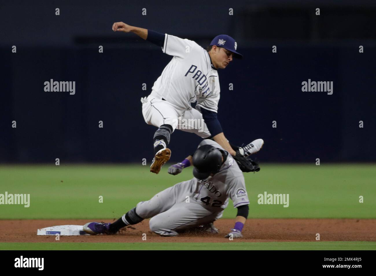 San Diego Padres second baseman Luis Urias, above, leaps over Colorado ...